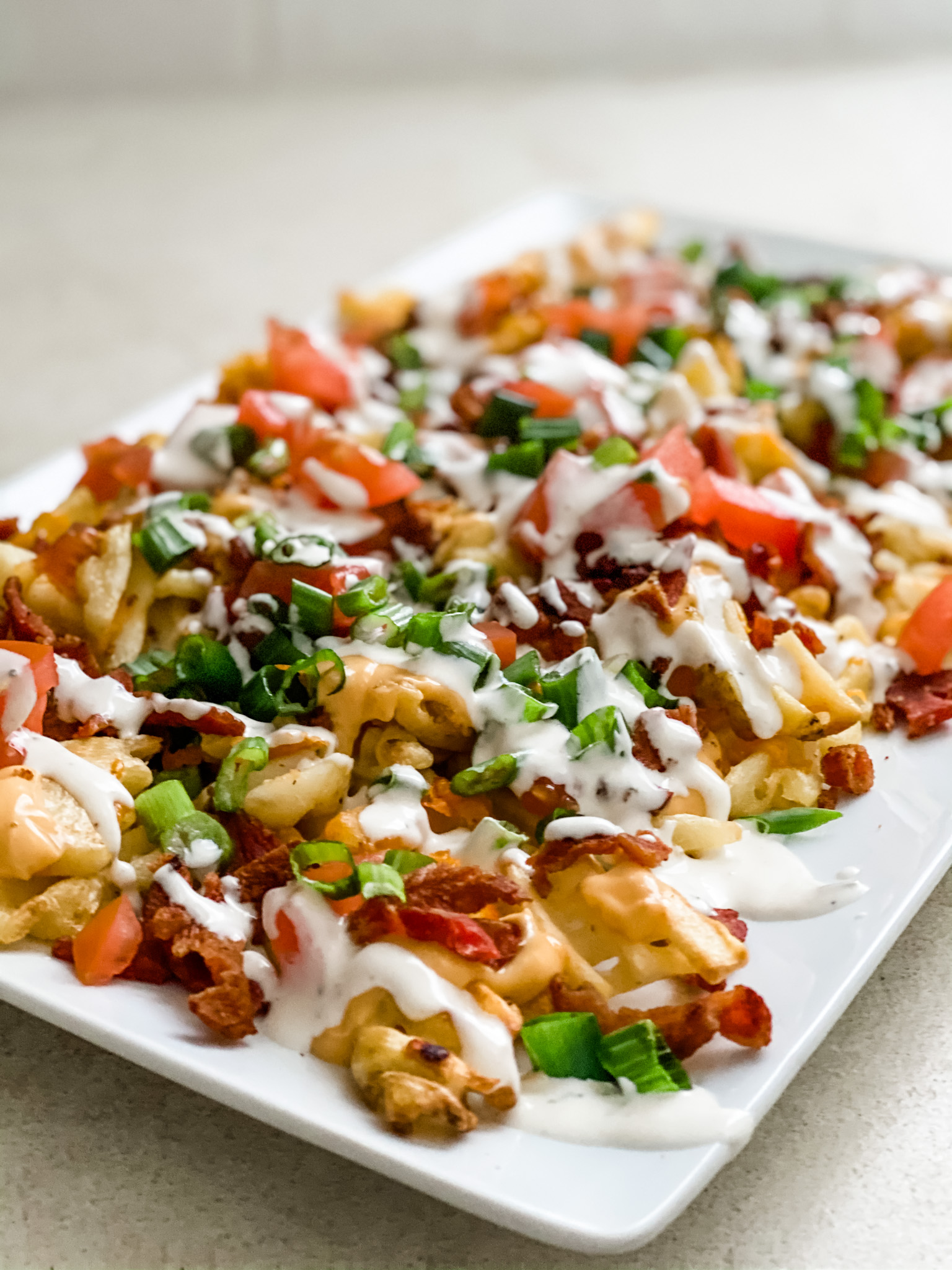 Idaho Nachos layered with crispy waffle fries, bacon, & ranch dressing.